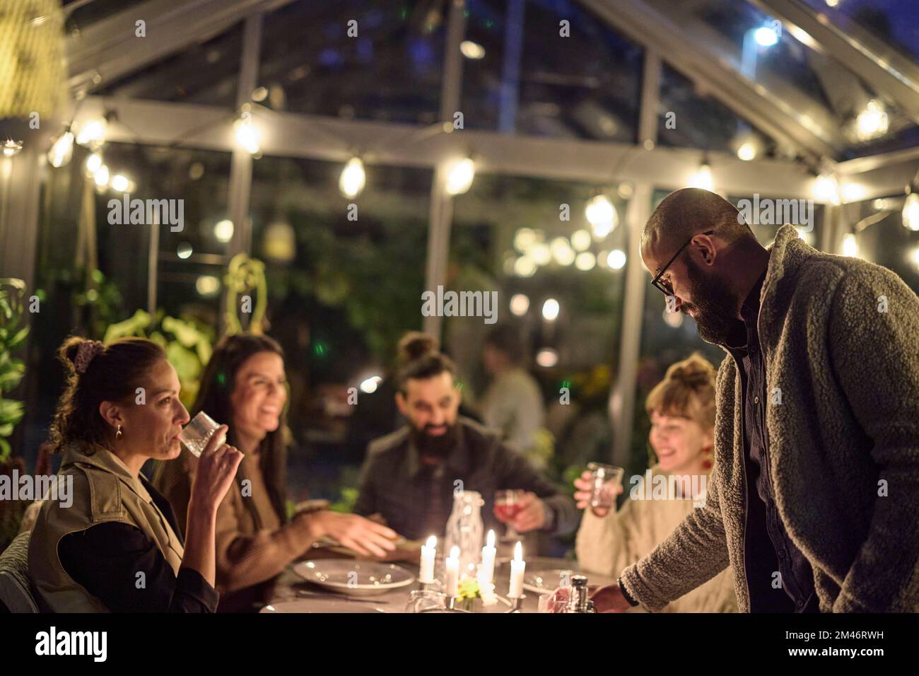 Happy friends having evening meal together Stock Photo - Alamy