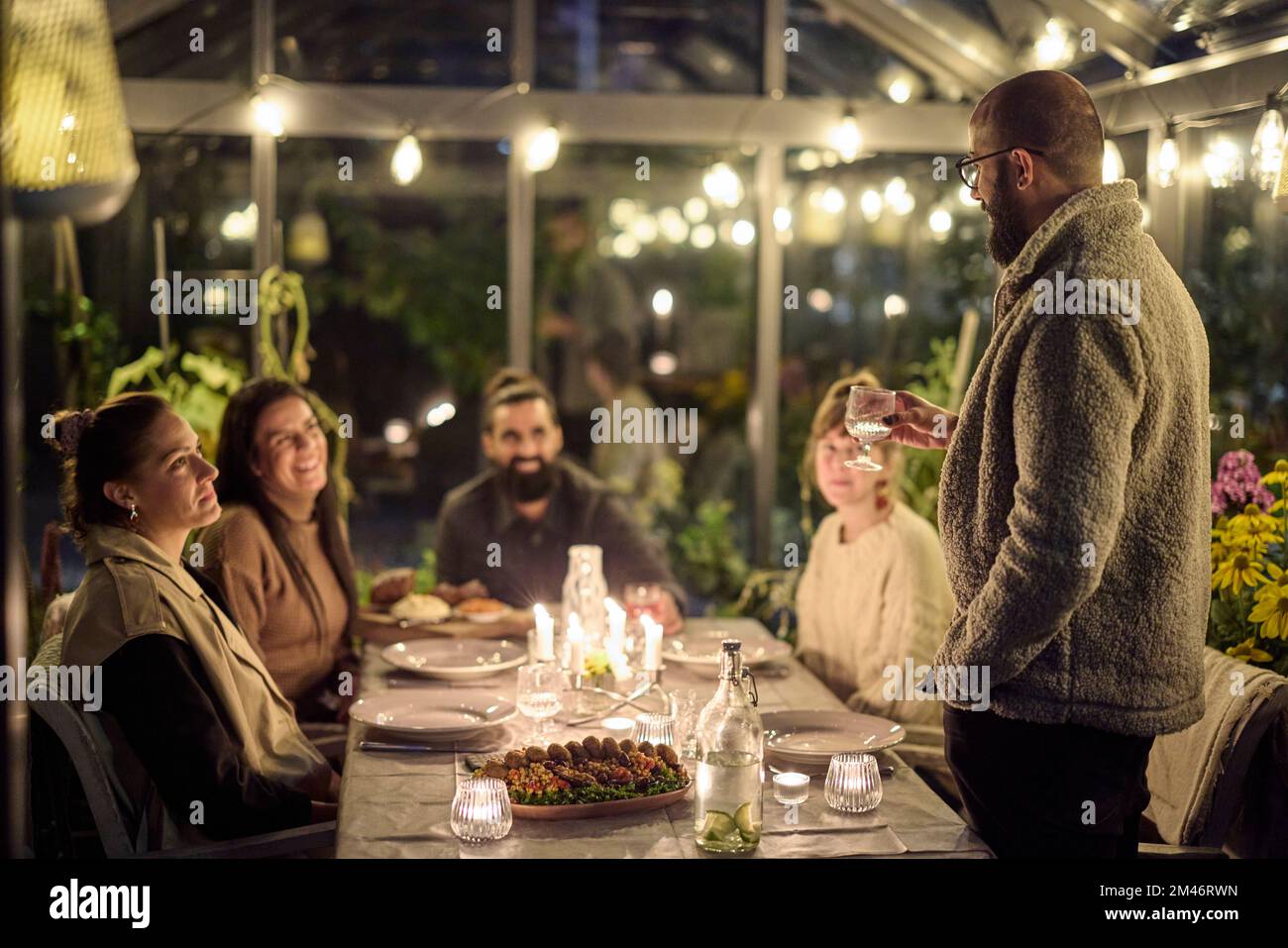 Happy friends having evening meal together Stock Photo - Alamy