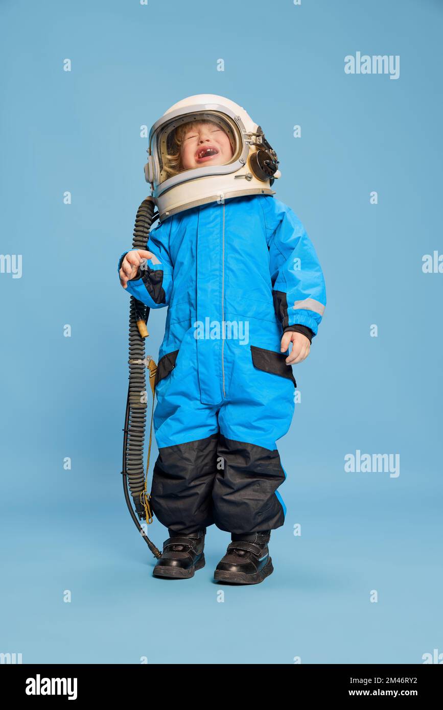 Portrait of little boy, child posing in astronaut costume and crying ...
