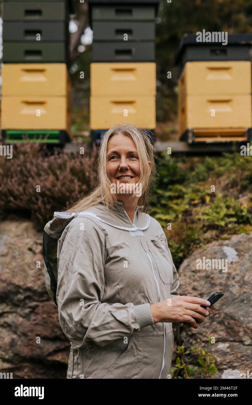 Beekeeper standing near beehive Stock Photo - Alamy