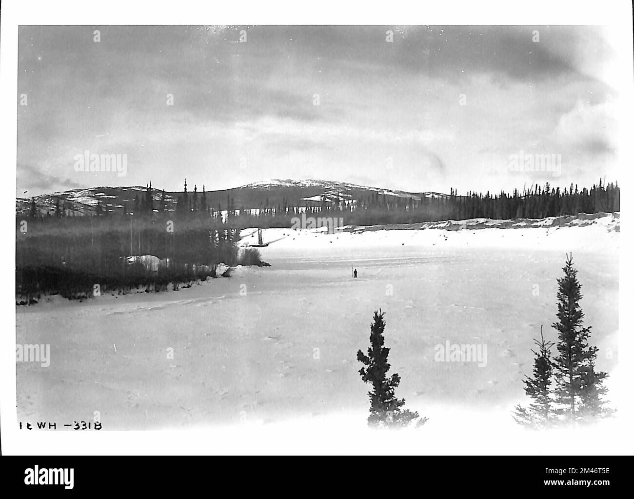 Looking down stream at the site of the permanent bridge across the Takhini River. Original ...