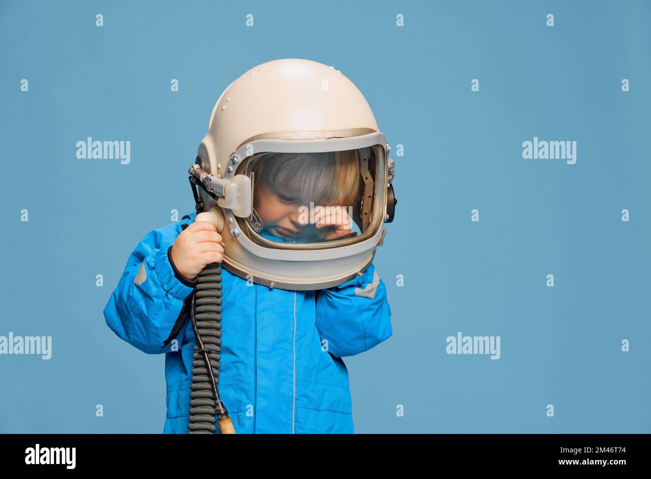 Portrait of little boy, child posing in astronaut costume, crying over ...