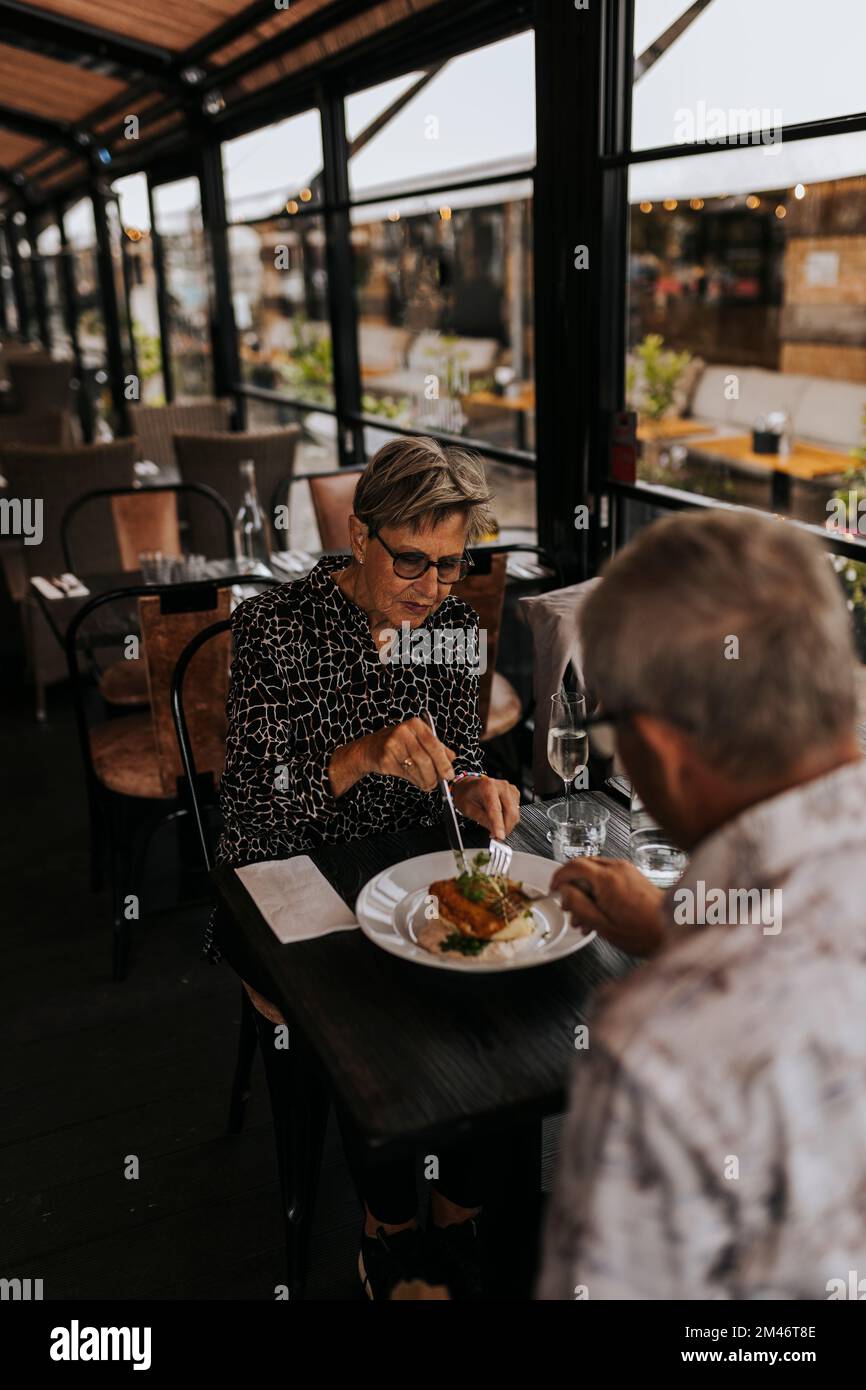 Senior couple sharing food in restaurant Stock Photo - Alamy