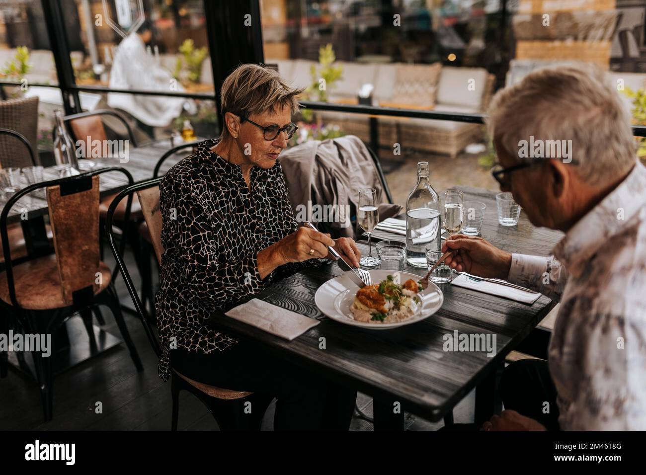 Senior couple sharing food in restaurant Stock Photo - Alamy