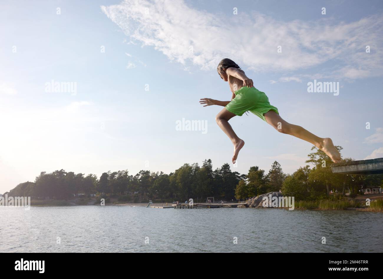 Boy jumping into water Stock Photo - Alamy