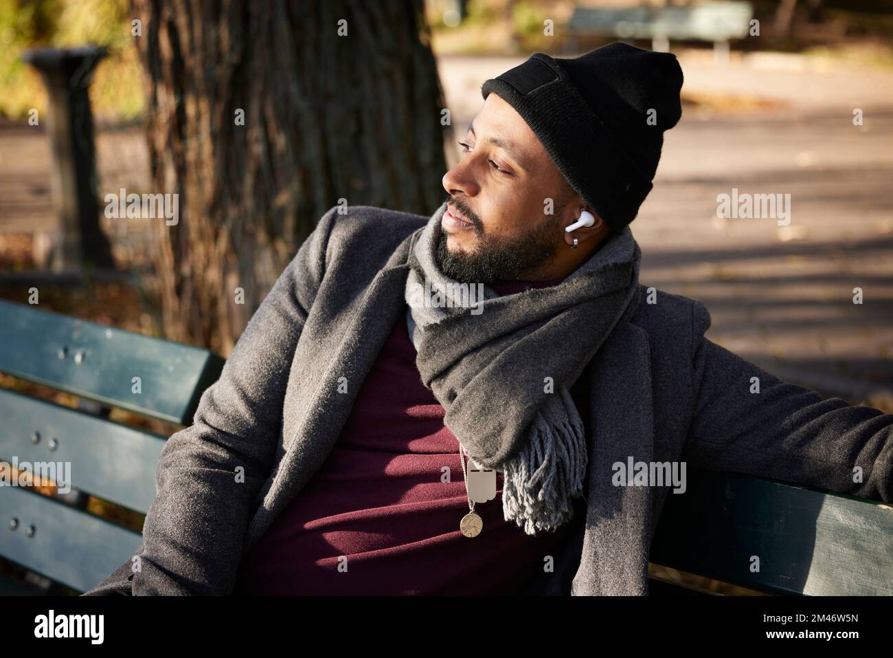 Smiling man sitting on bench Stock Photo - Alamy