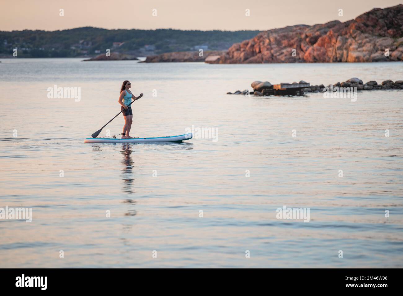 Woman paddleboarding at sea Stock Photo - Alamy