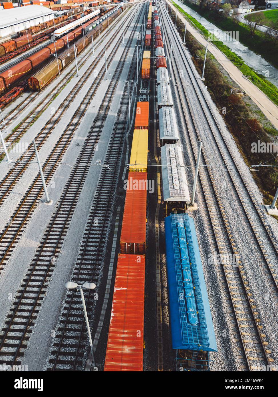 Vertical photo of colorful cargo trains in lines, standing still at the ...