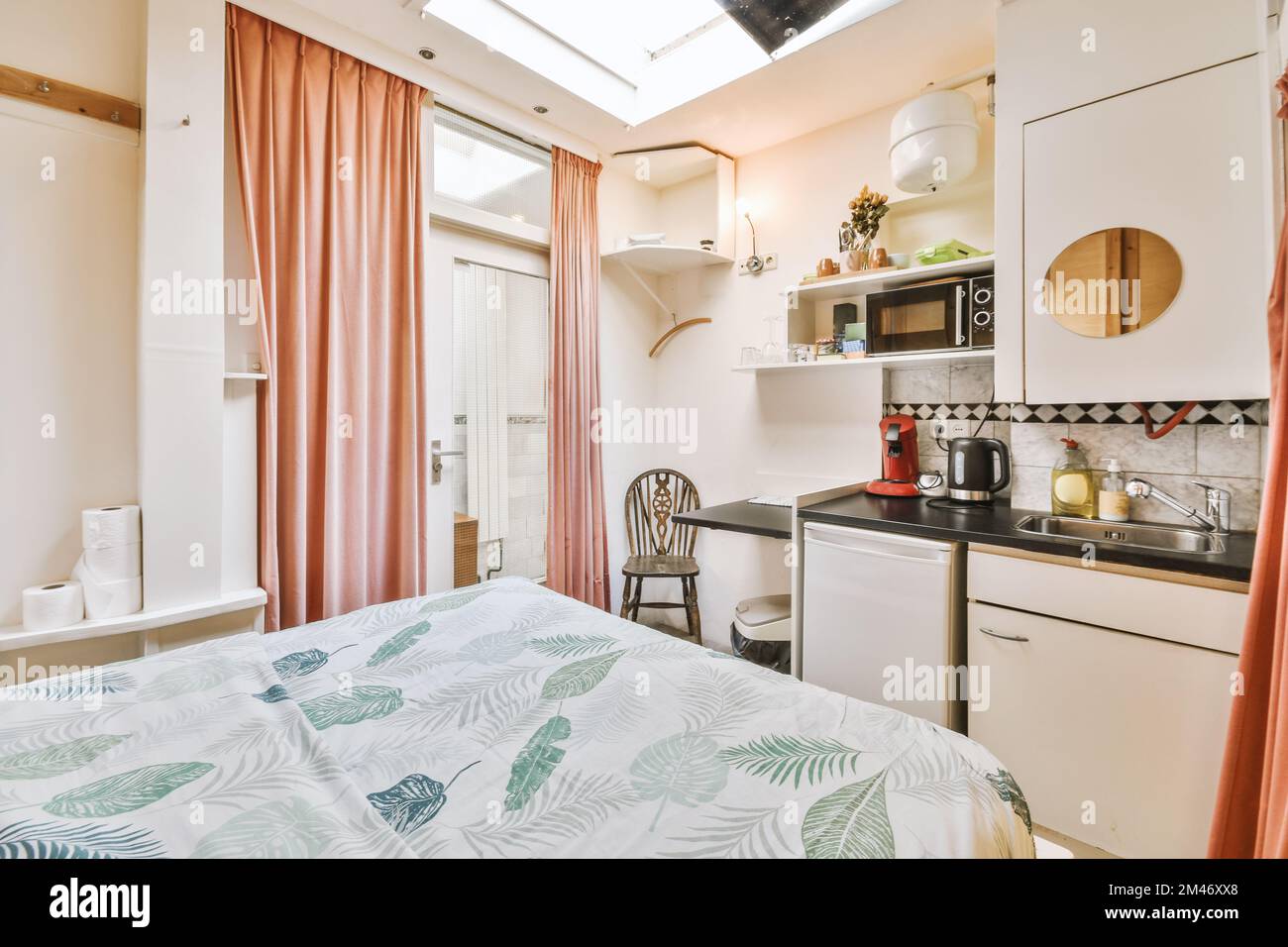 a bedroom with a bed, sink and microwave on the wall in front of the ...