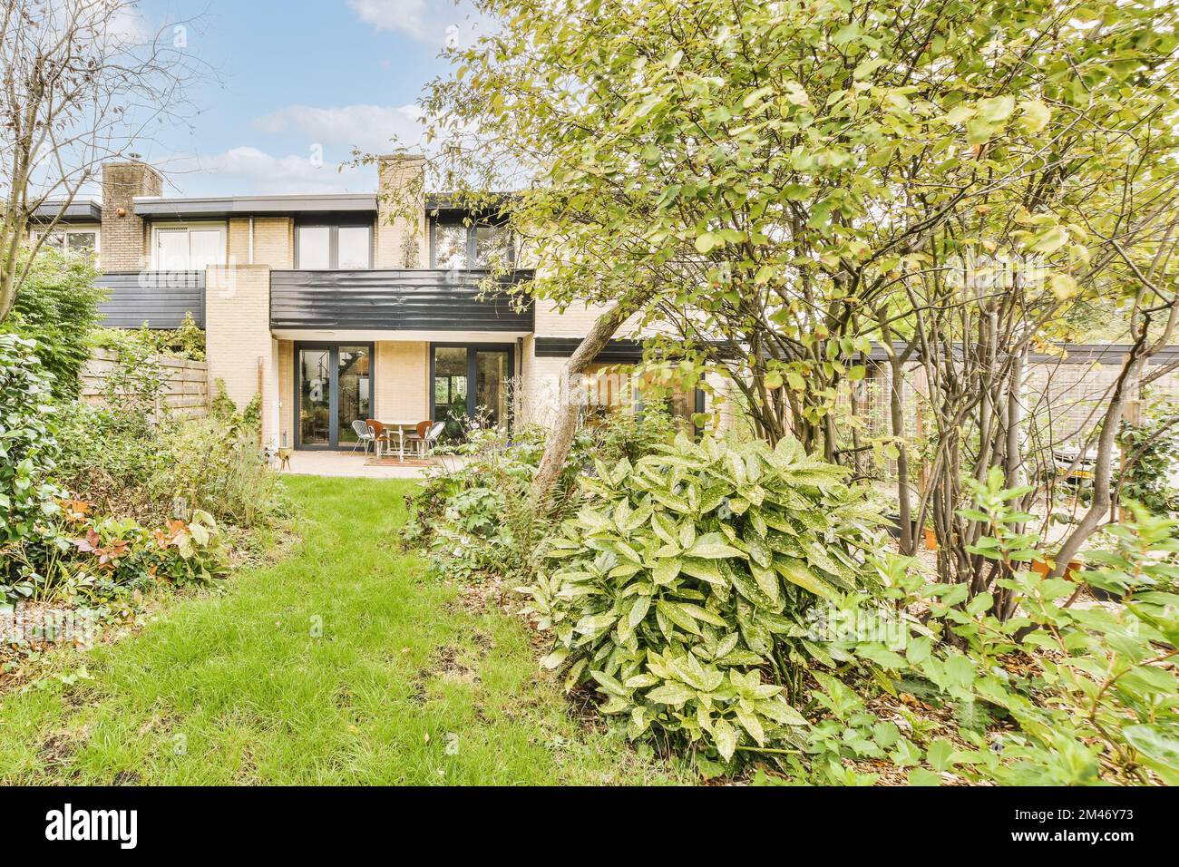 an outside view of a house with trees and bushes in the foreground area ...