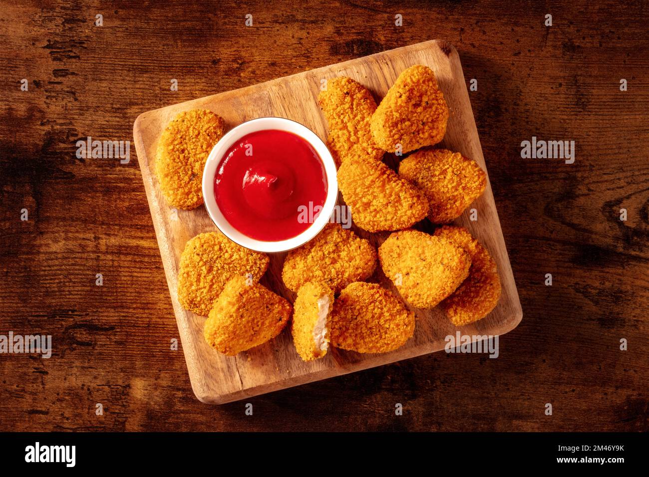 Chicken nuggets on a rustic wooden table, overhead flat lay shot. A ...