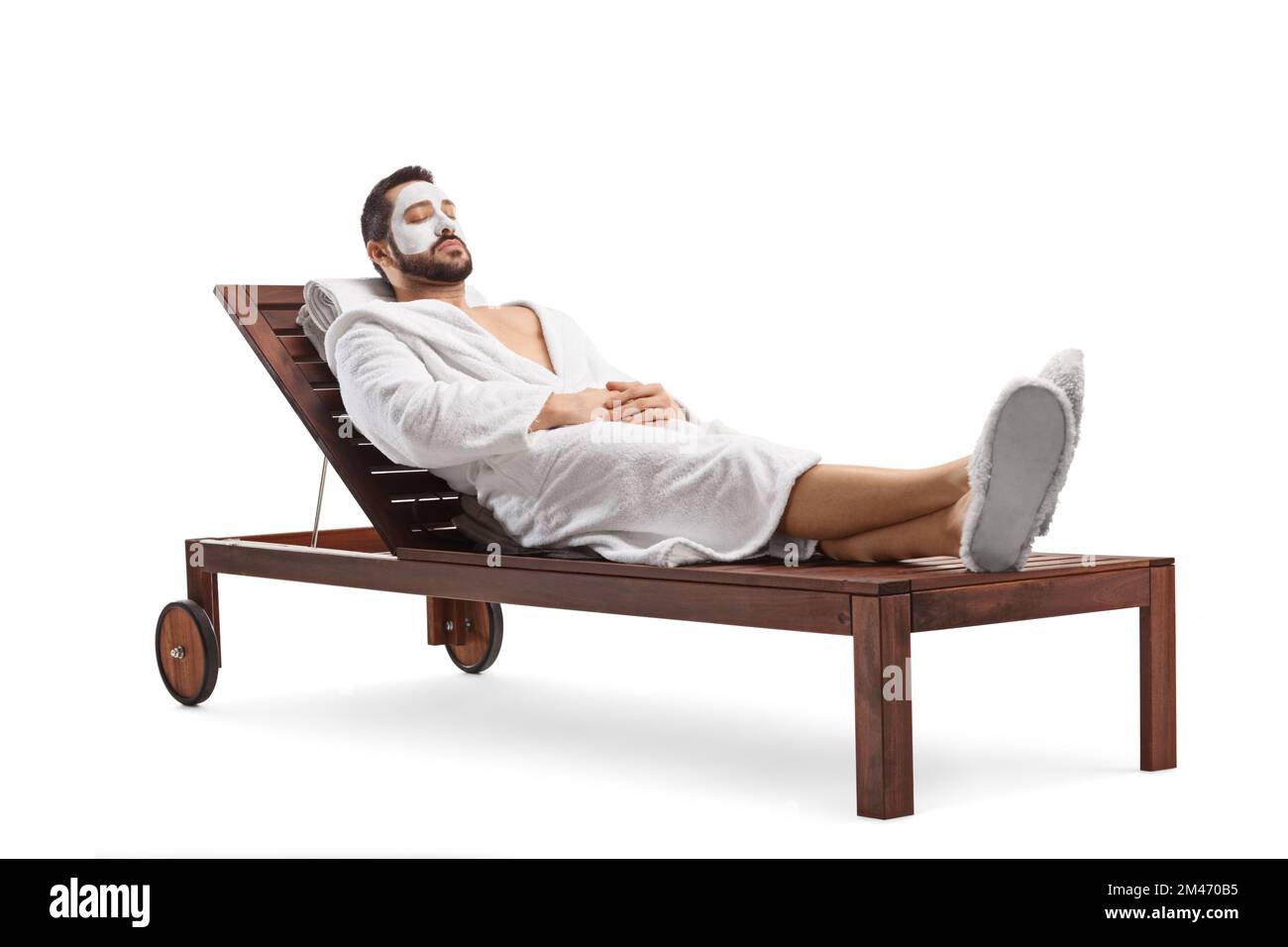 Man in a bathrobe with a face mask laying on a lounge chair isolated on ...