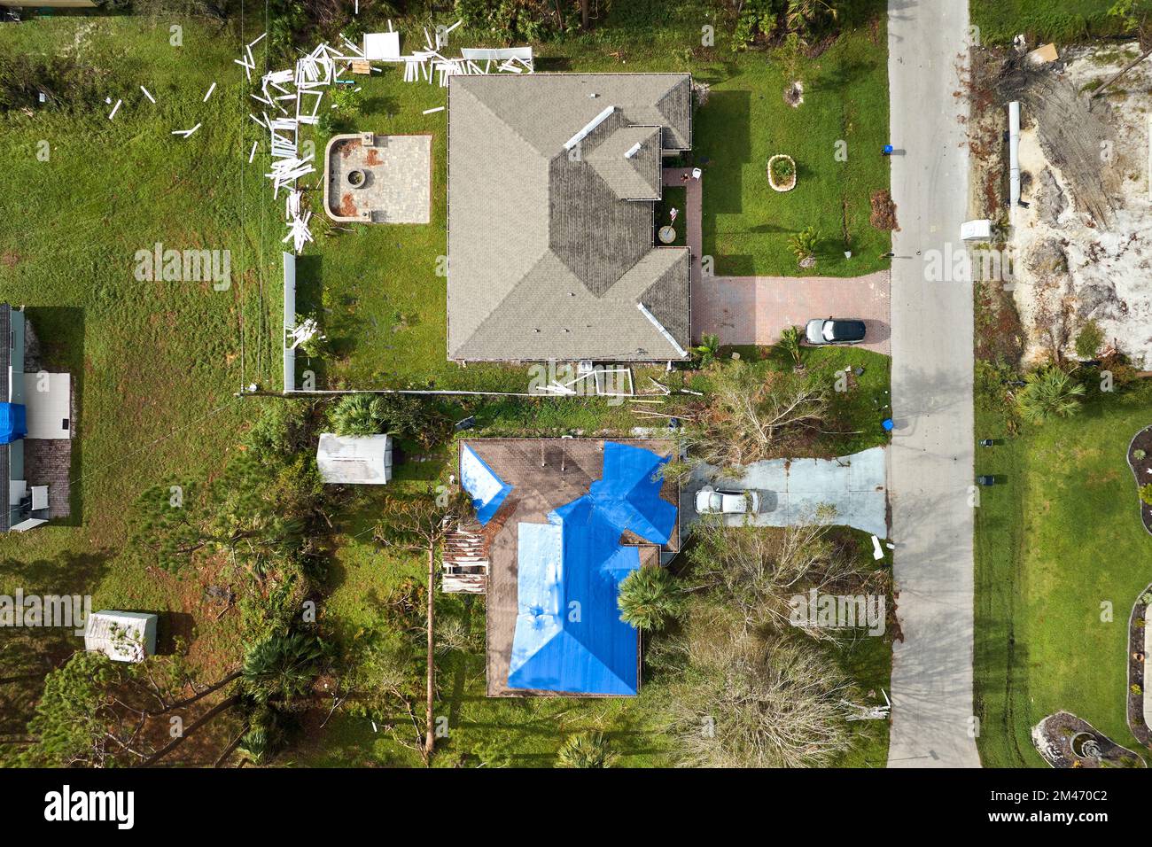 Aerial view of damaged in hurricane Ian house roof covered with blue ...