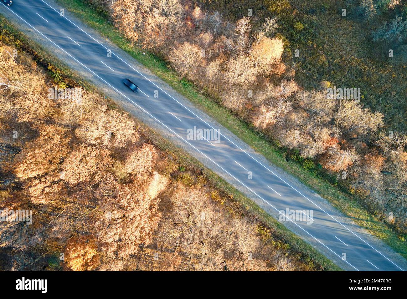 Aerial view of intercity road with blurred fast driving car at sunset ...