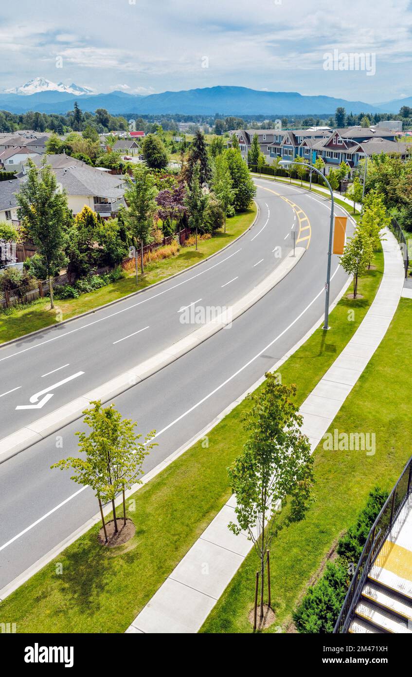 Road leading through residential area with mountain view on skyline ...