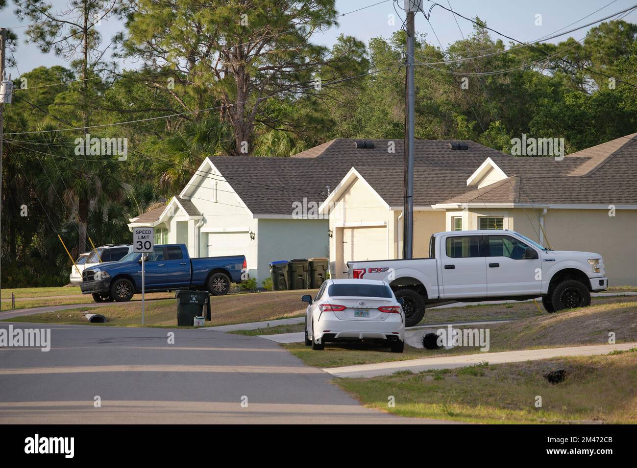Car parked in front of wide garage double door on concrete driveway of ...
