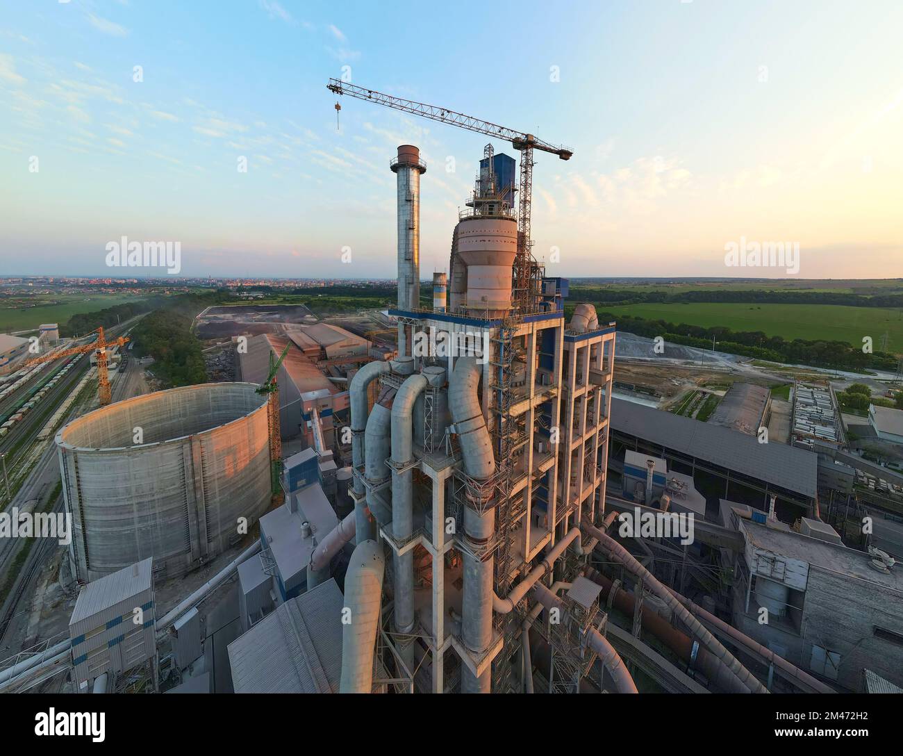 Cement plant with high factory structure and tower cranes at industrial ...