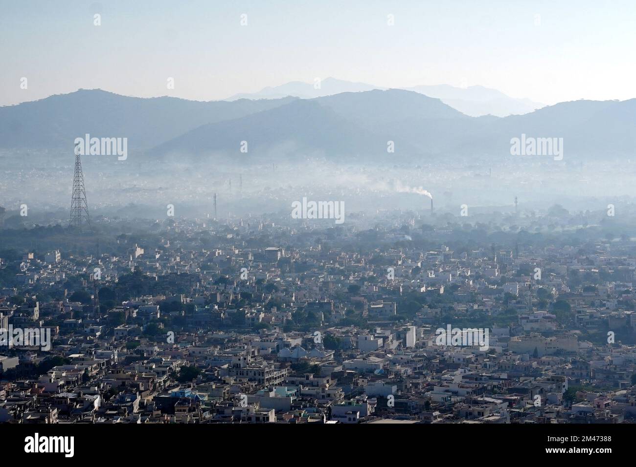 Smoke billows from the chimney of a factory as a thick layer of smog ...