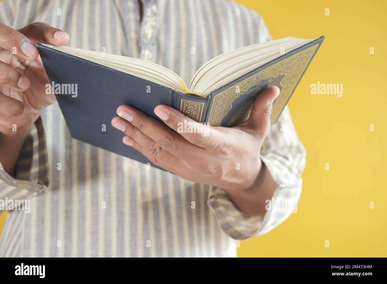 muslim man hand holding Holy book Quran with copy space Stock Photo - Alamy