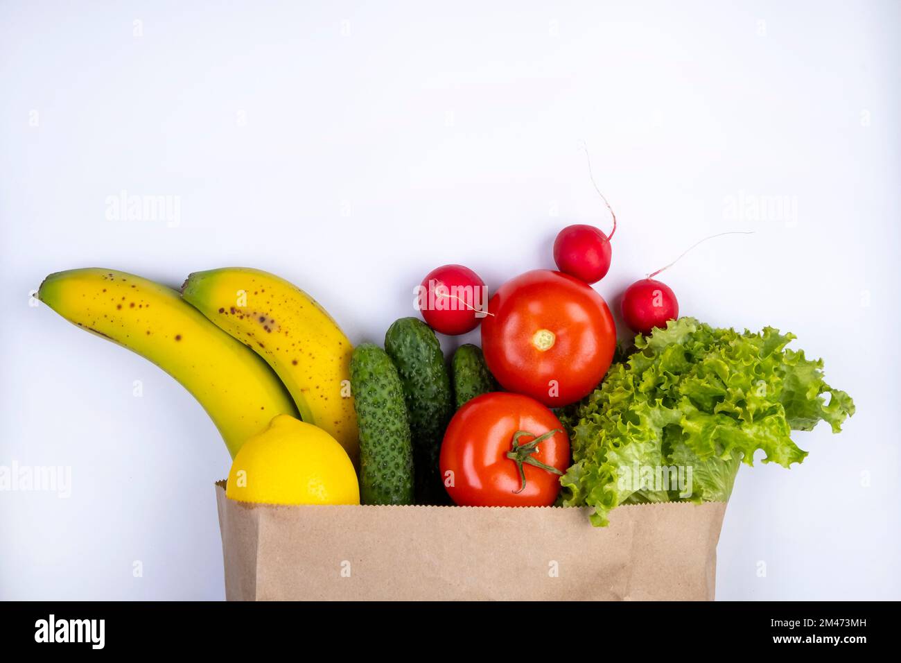 paper bag with products, vegetables and fruits on a white background ...