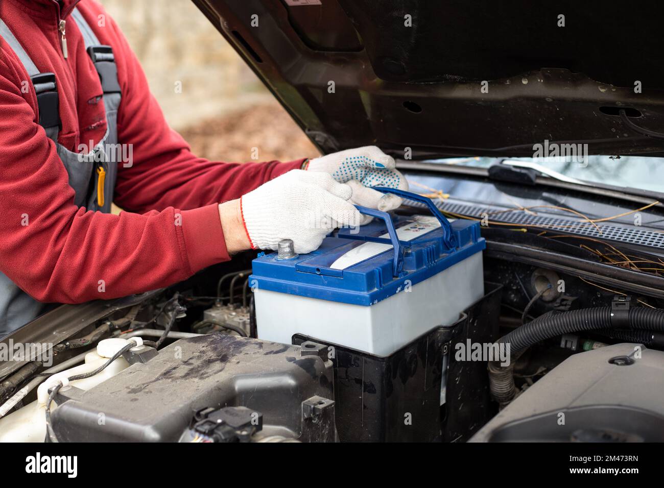 mechanic replaces the car battery. Discharging the battery and ...