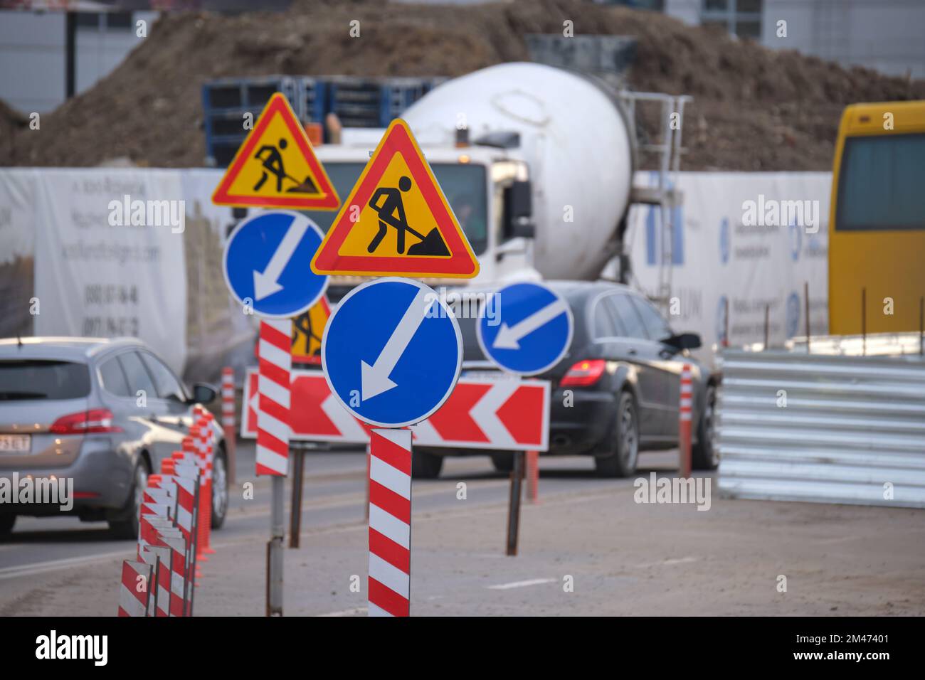 Roadworks warning traffic signs of construction work on city street and slowly moving cars Stock ...
