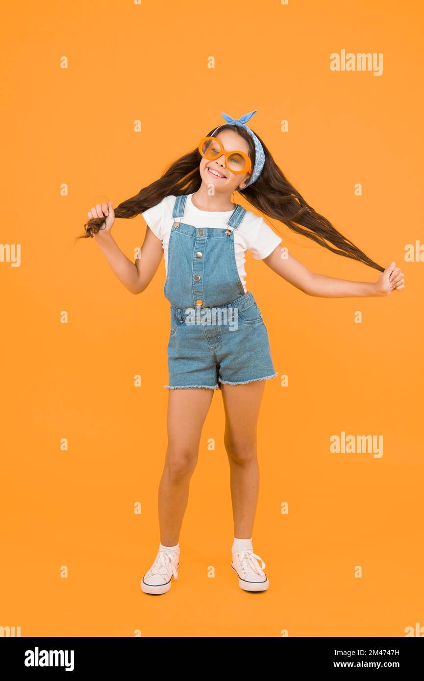 strong hair. spring kid fashion. cheerful little girl yellow background ...