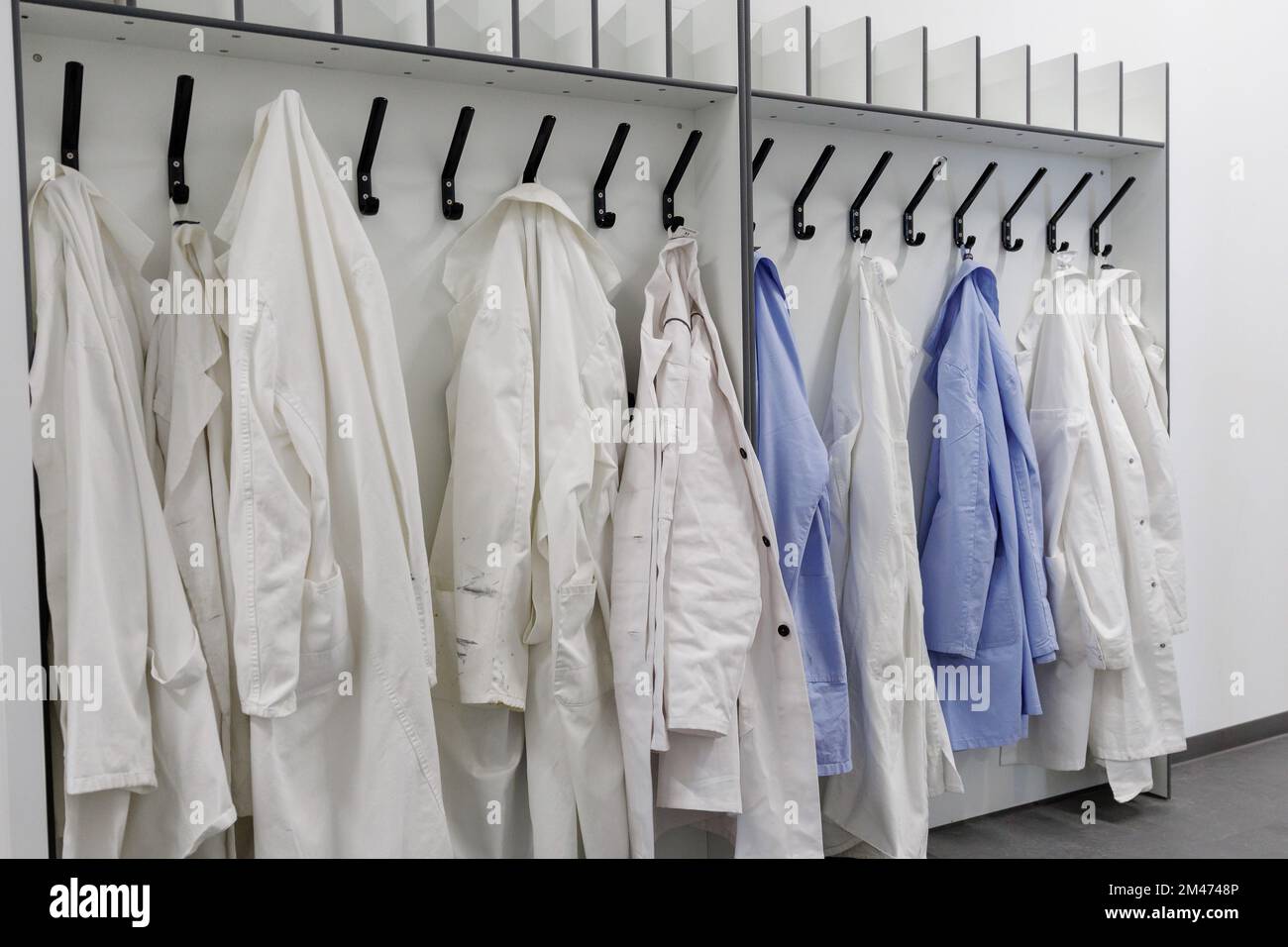 Erlangen, Germany. 19th Dec, 2022. Lab coats hang on coat hooks in the ...