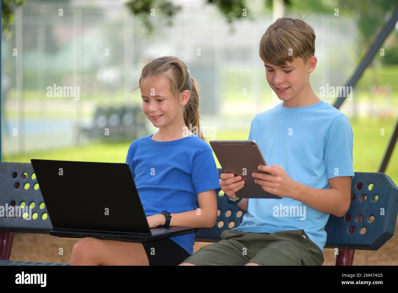 Two children teenager boy with laptop computer and young girl with ...