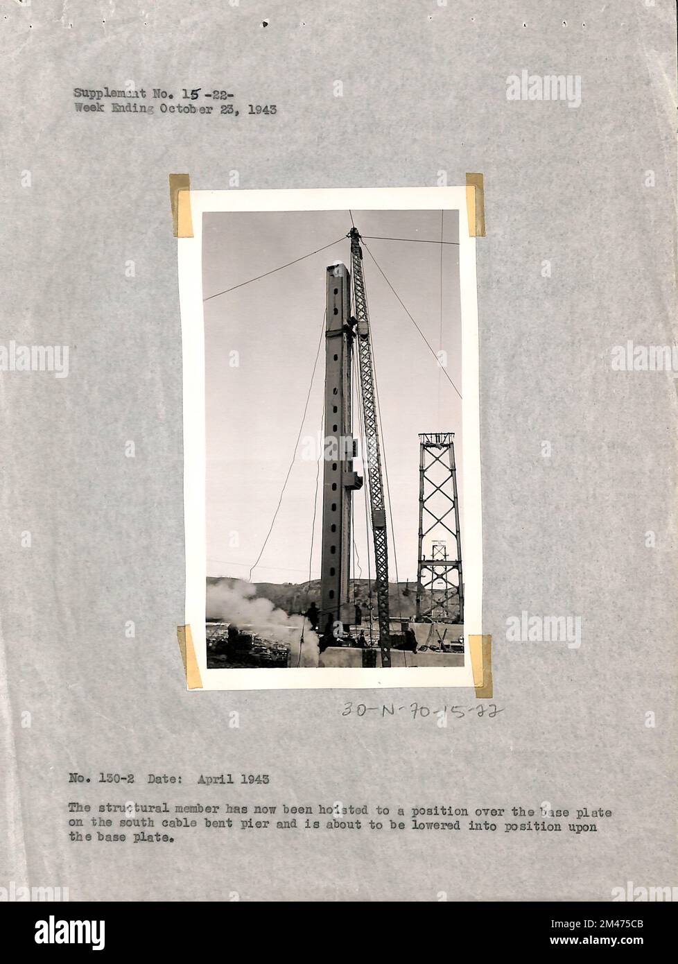 A structural member being lowered onto the base plate. Original caption ...