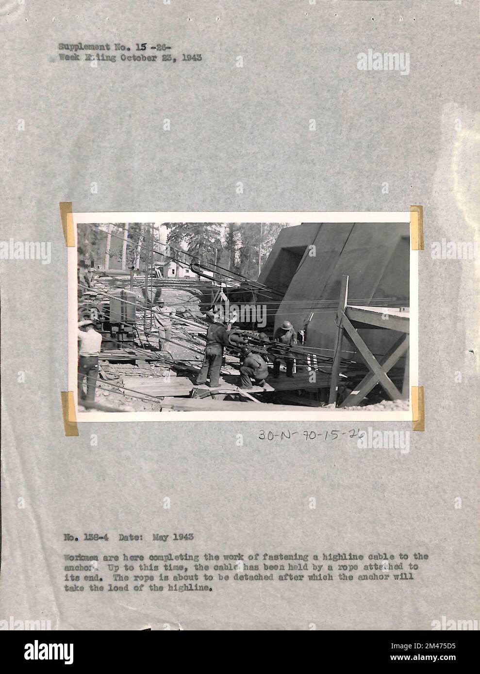 Fastening a highline cable to the anchor. Original caption: Workmen are ...