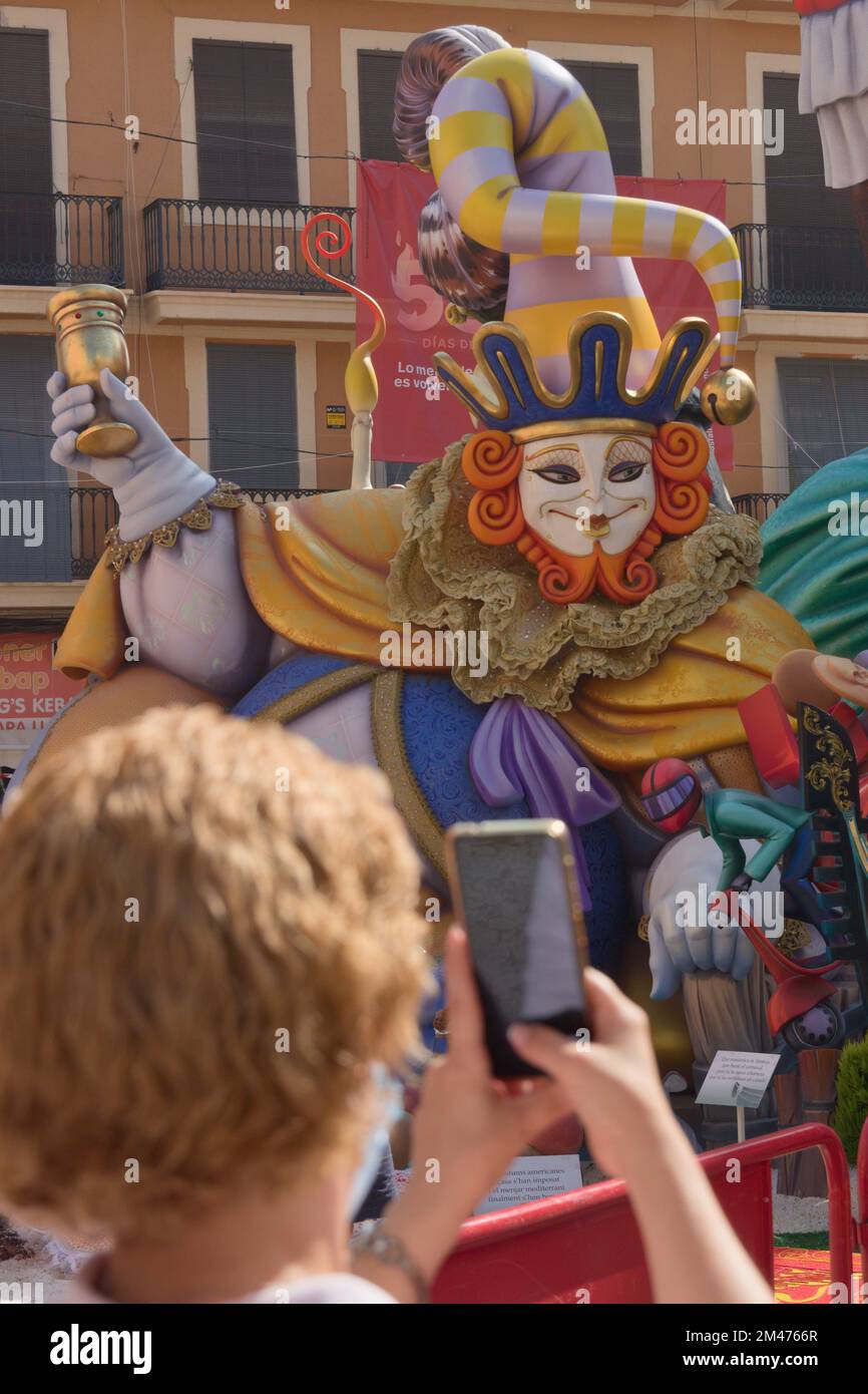 An unrecognizable woman takes pictures of the Fallas monument that she ...
