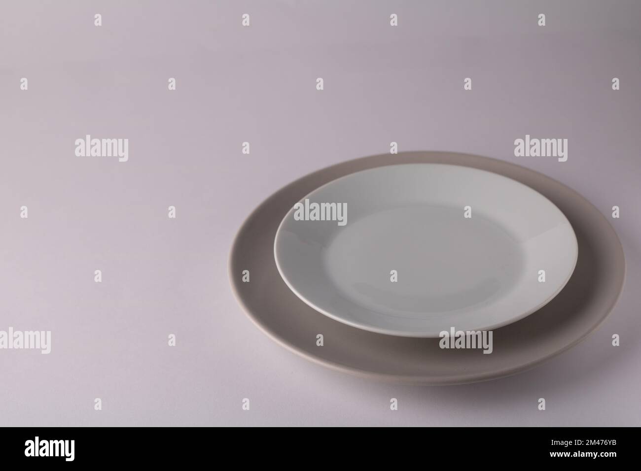 photo of two round plates on top of each other on a white background ...