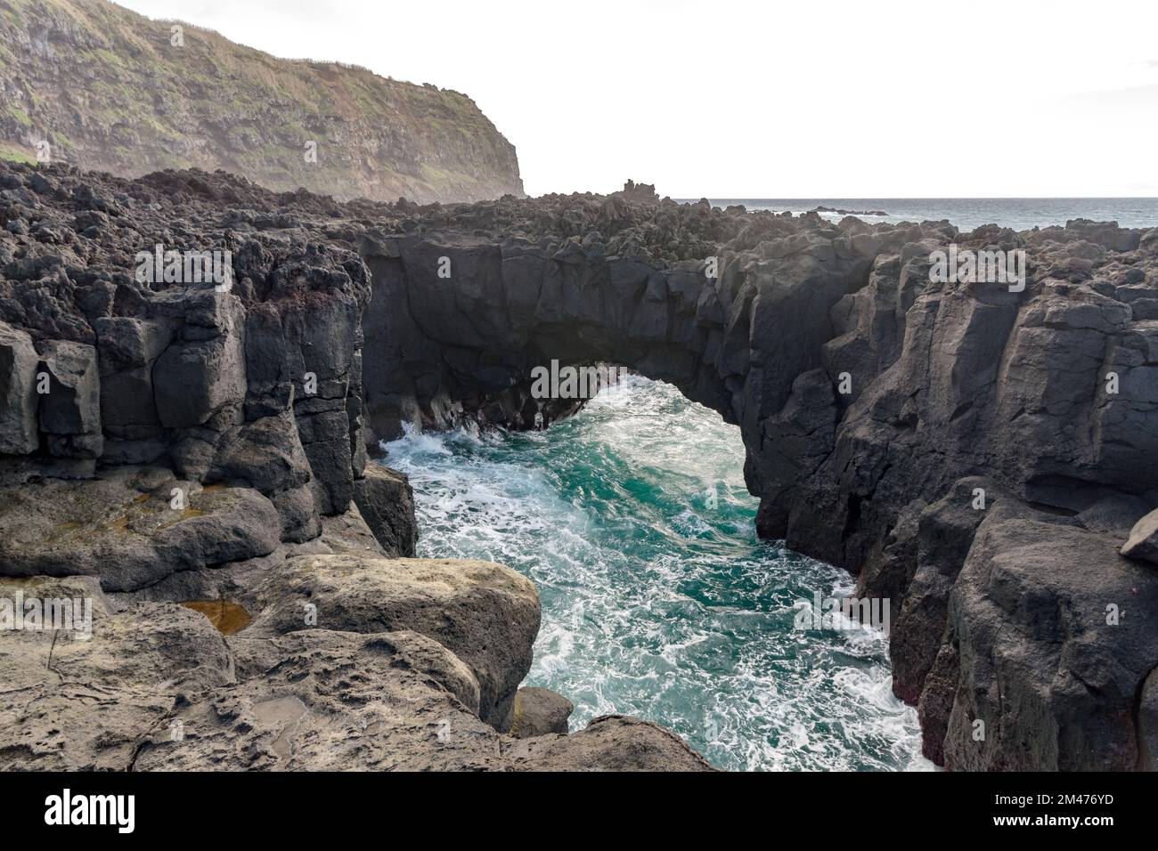 Lava cliff with a rock arch in the area of Ponta da Ferraria on the ...