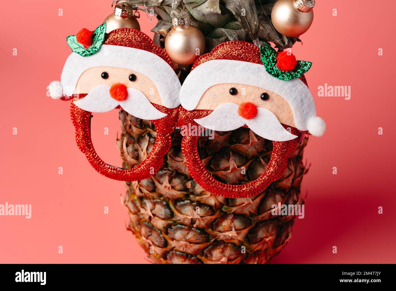 Creative pineapple with Christmas decorations on studio background ...