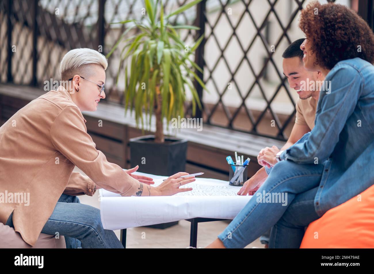 Cheerful architectural team working on a technical drawing Stock Photo ...