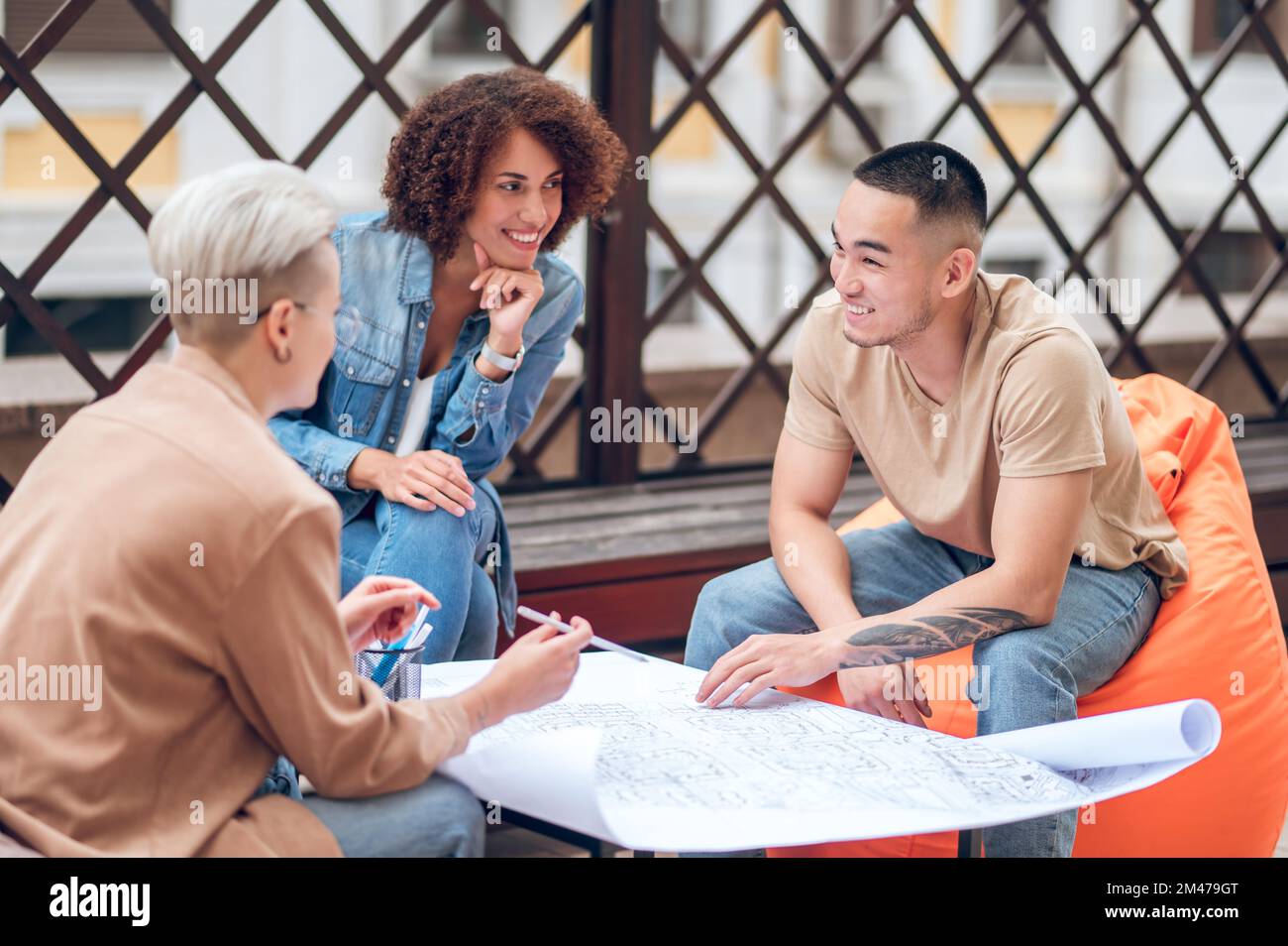 Architectural team engaged in discussing a technical drawing Stock ...