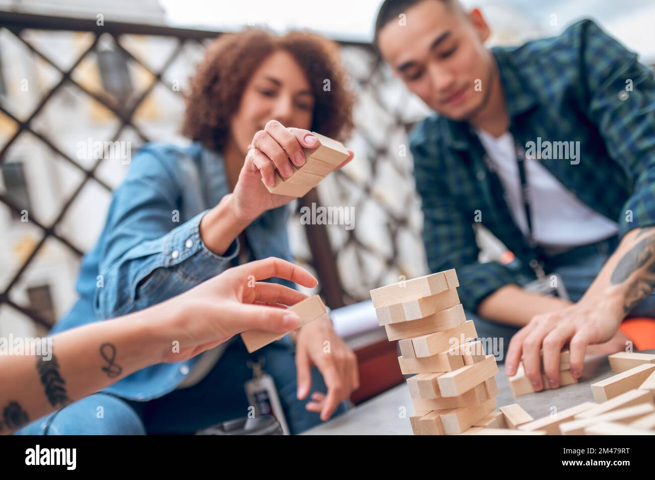 Group of company employees playing jenga on the veranda Stock Photo - Alamy