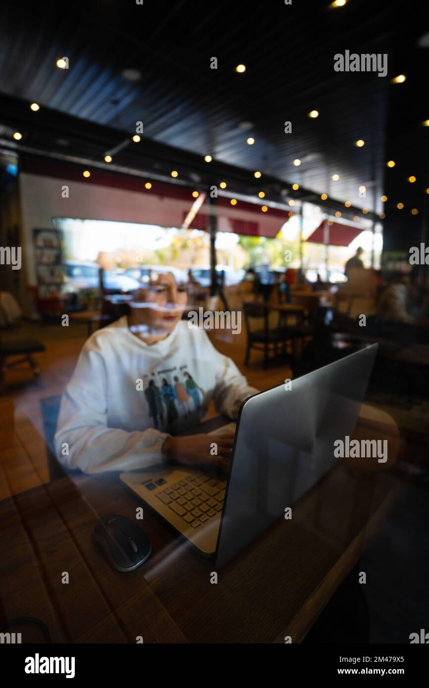 Woman sitting in coffee shop and using computer Stock Photo - Alamy