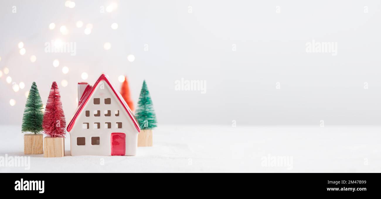 Ceramic christmas miniature house with spruce on the white background ...