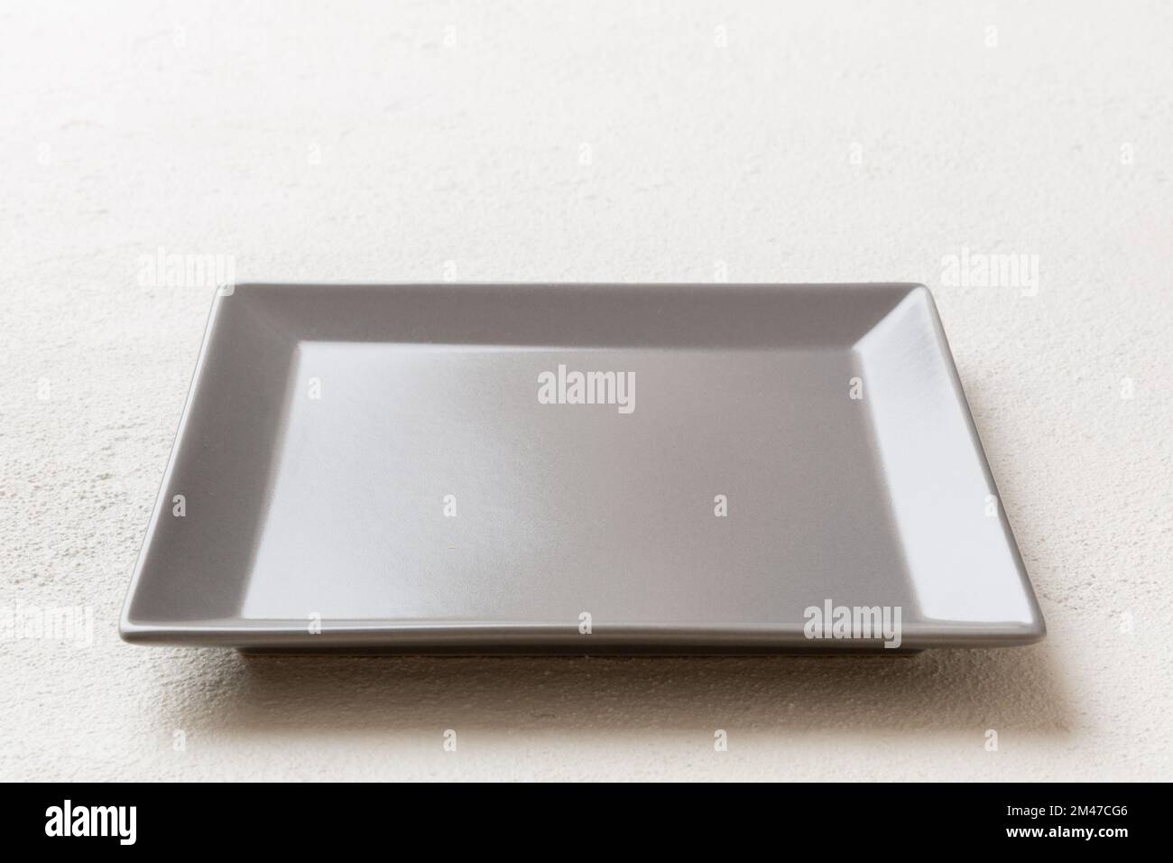 Perspective view of empty square plate on cement background. Empty ...