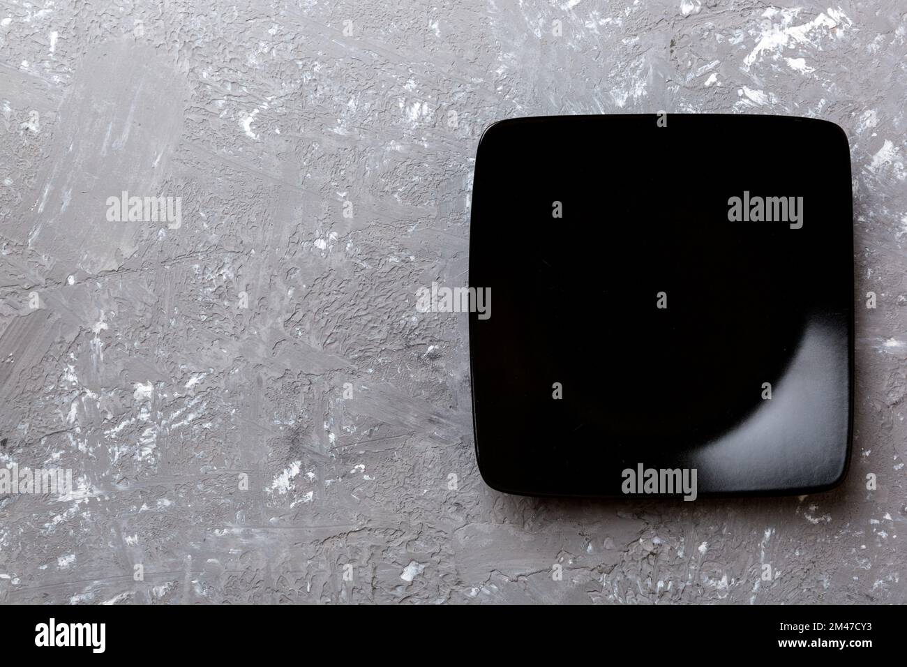 Top view of empty square plate on cement background. Empty space for ...