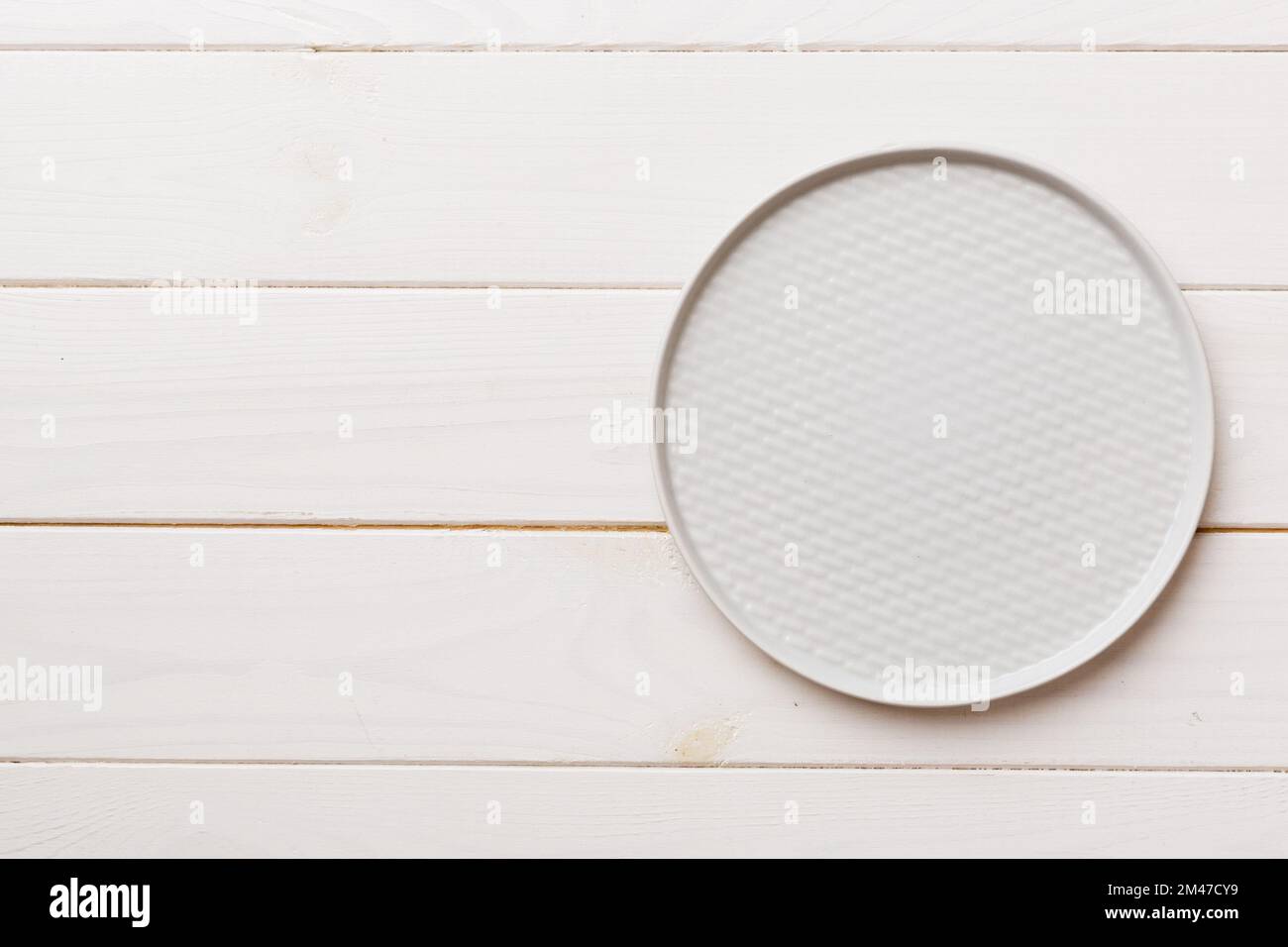Top view of empty light plate on wooden background. Empty space for ...