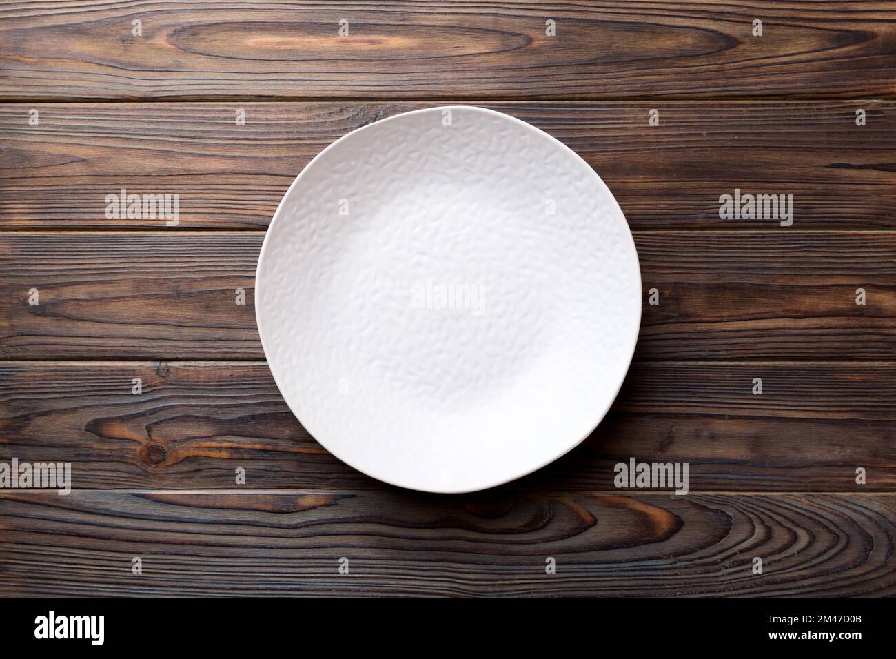 Top view of empty light plate on wooden background. Empty space for ...