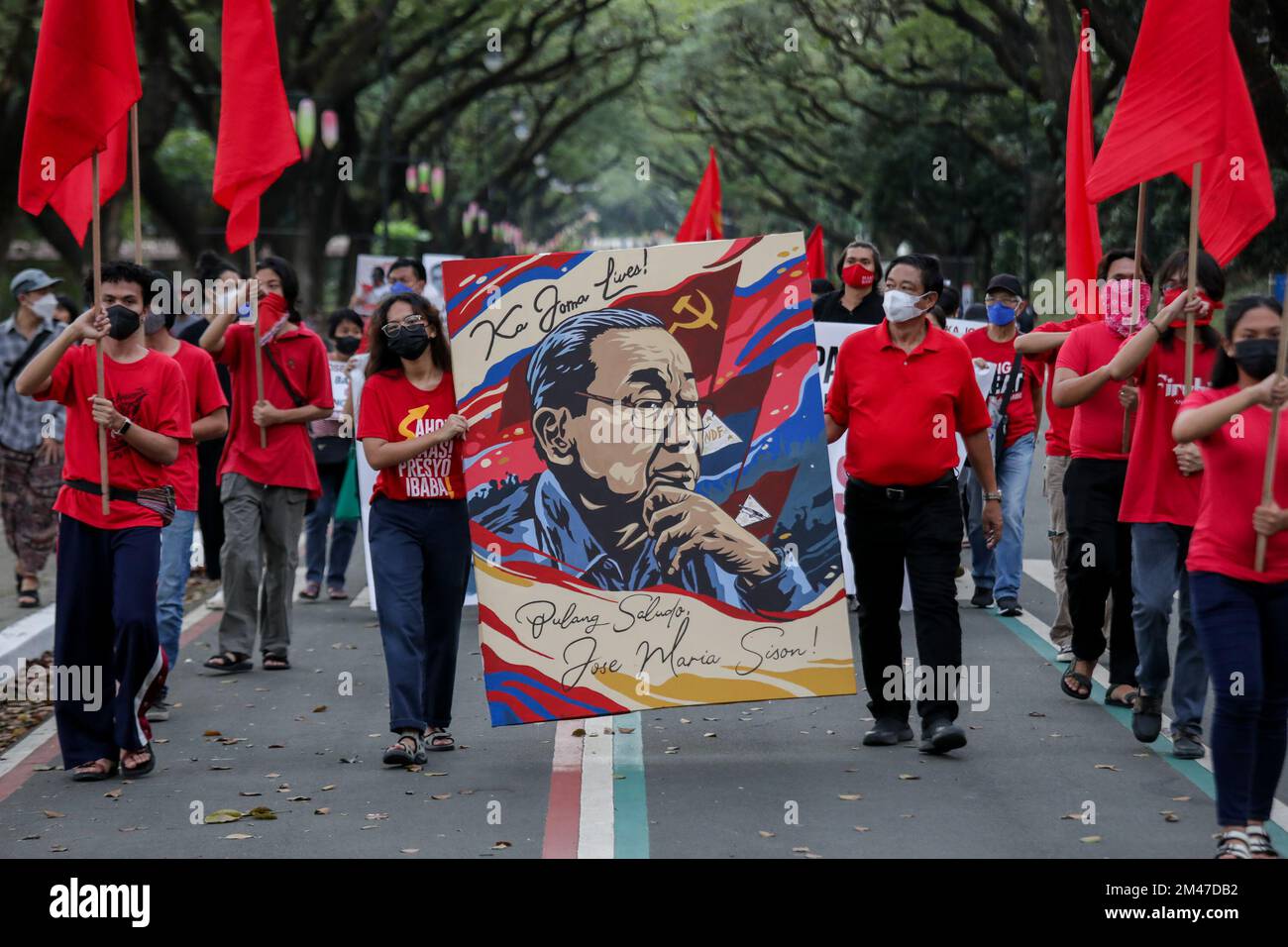 Manila, Philippines. 19th Dec, 2022. Filipino activists carry flags and a poster of Jose Maria ...