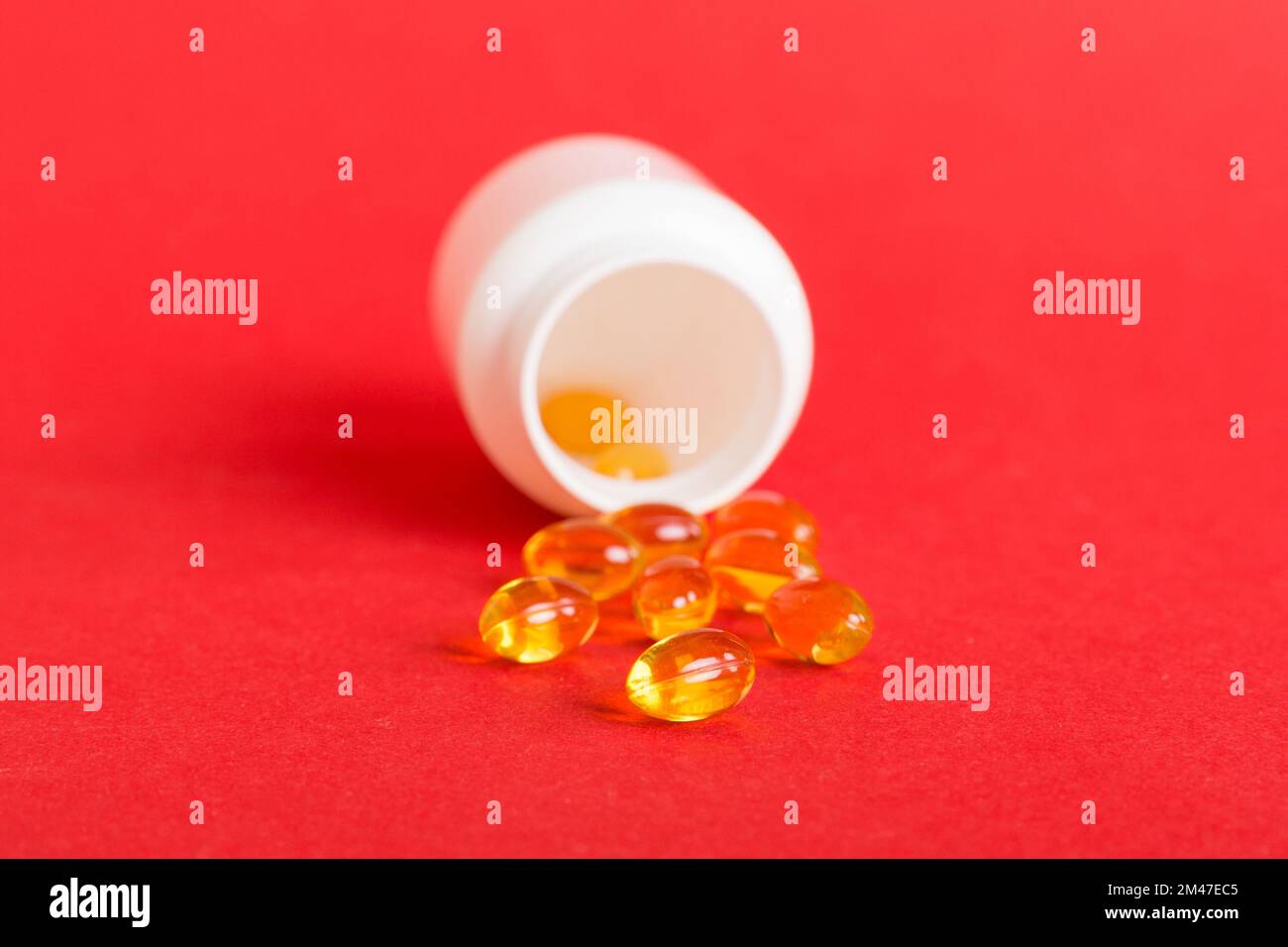 Soft gels pills with Omega-3 oil spilling out of pill bottle close-up ...