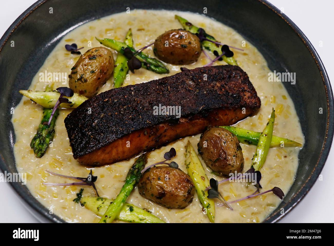 blackened salmon with creamy leek fondue and roasted potatoes Stock ...