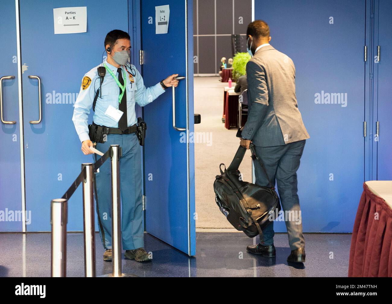 A United Nations security officer opens the door for a delegate into a ...