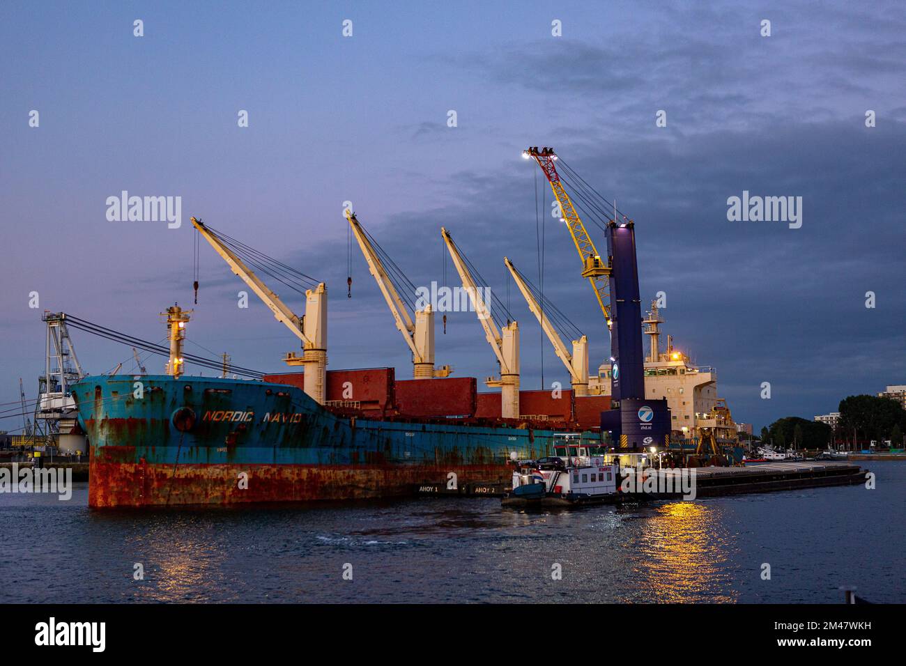 Industrial inland shipping colourful cranes in port at sunset blue hour ...