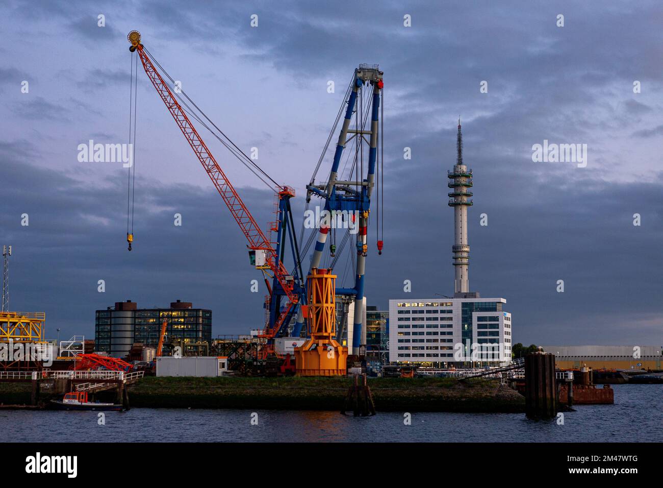 Industrial inland shipping colourful cranes in port at sunset blue hour ...